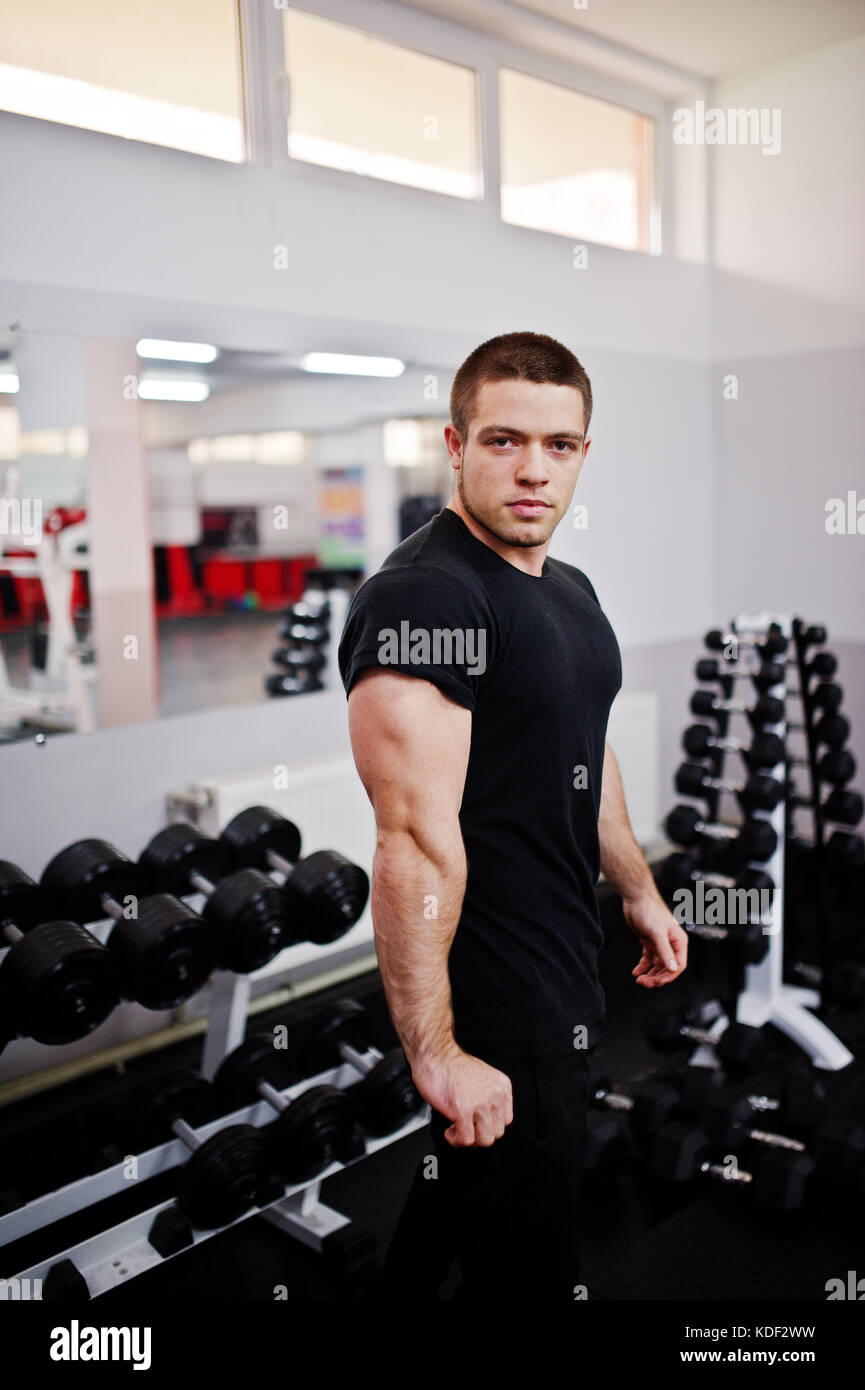 Young man doing exercises and working hard in gym and enjoying his ...