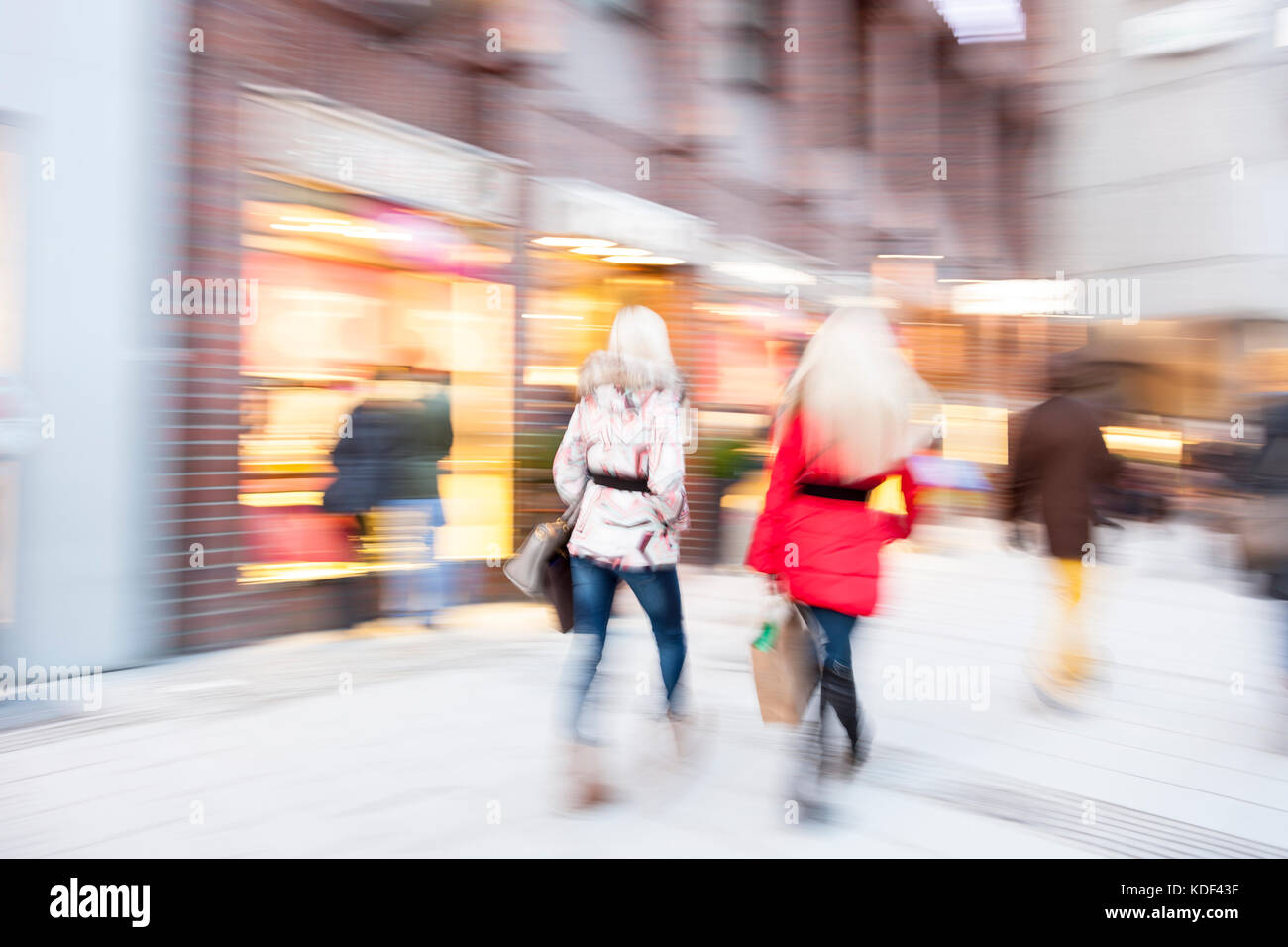 A young shoppers walking against shop window Stock Photo - Alamy