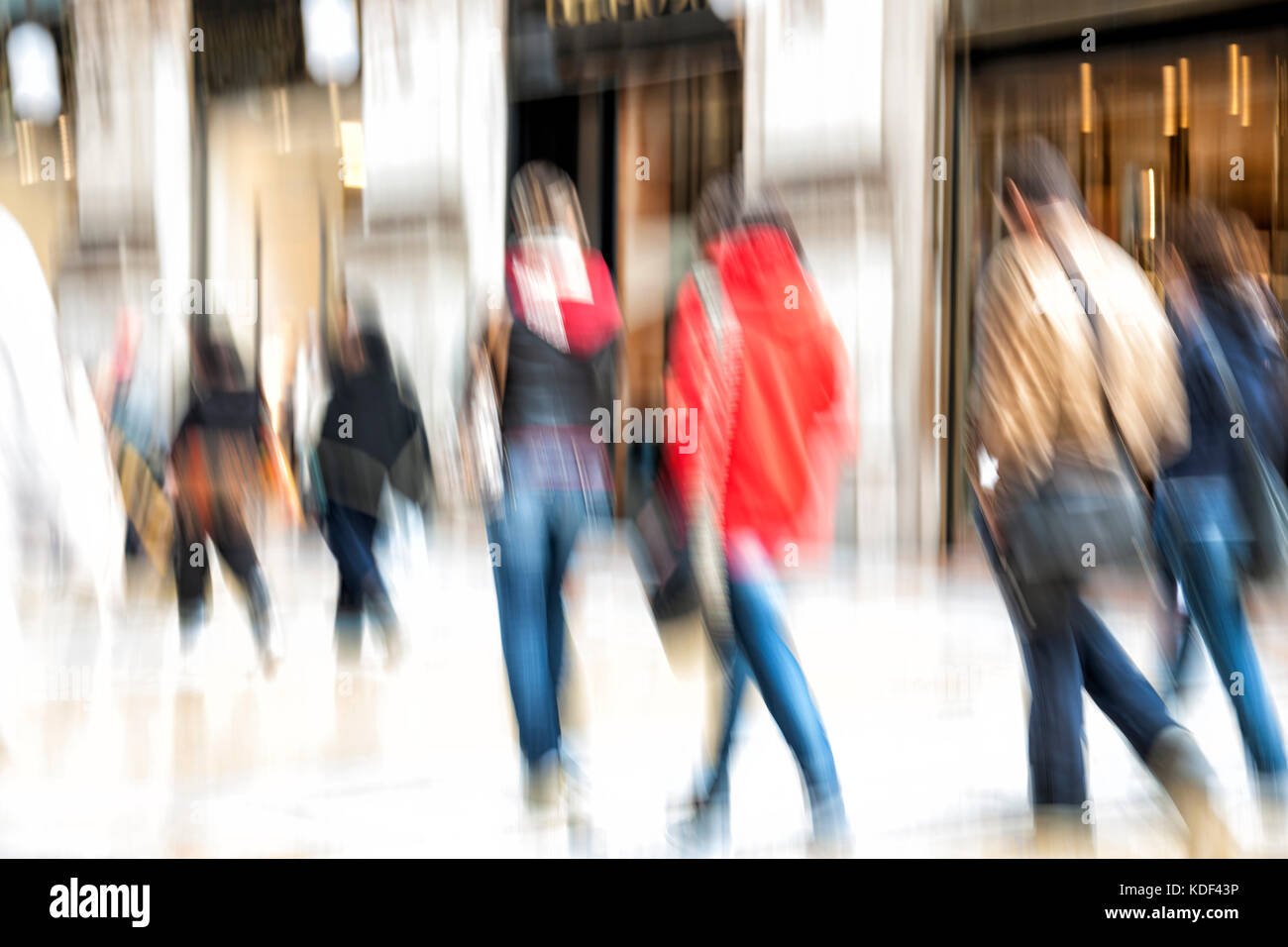 Young shoppers walking against shop window Stock Photo - Alamy
