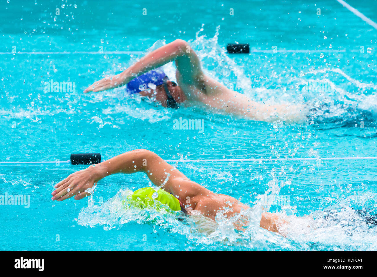 Two male swimmers competing in freestyle stroke at a local swimming ...