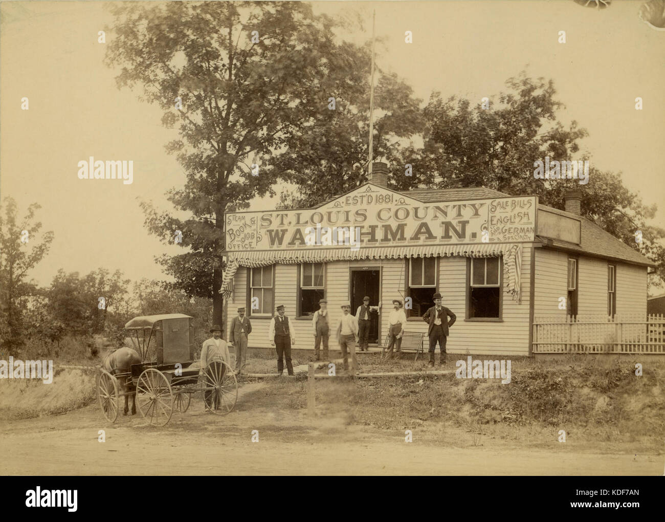 St. Louis County Watchman office with men posing in front, one by a ...