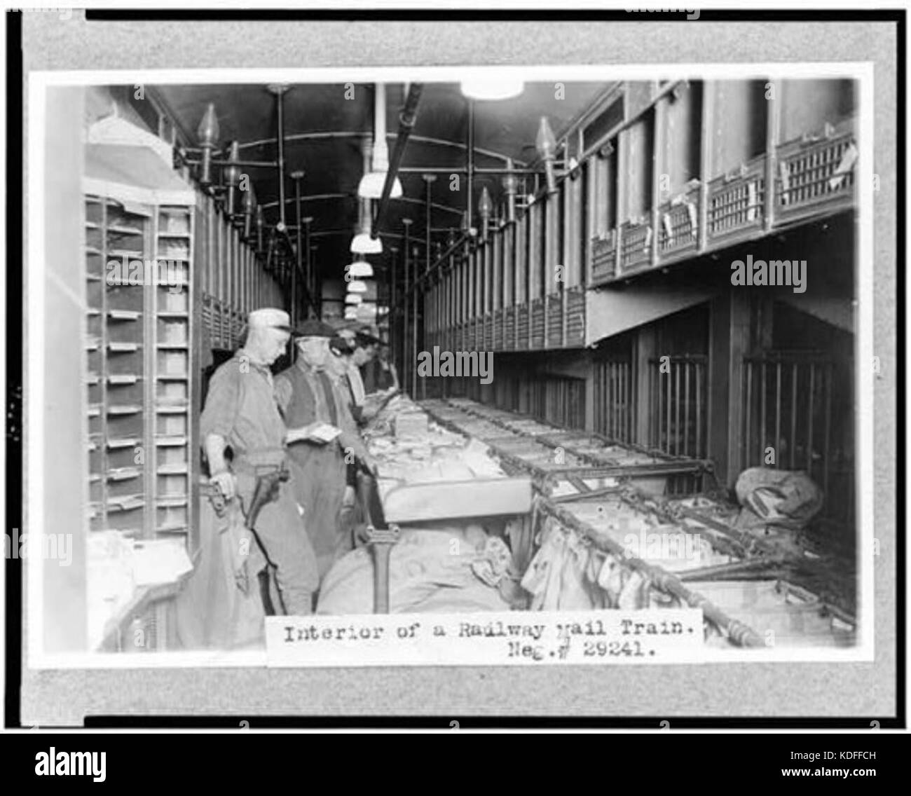 A historical photograph of U.S. postal workers sorting mail in a rail ...