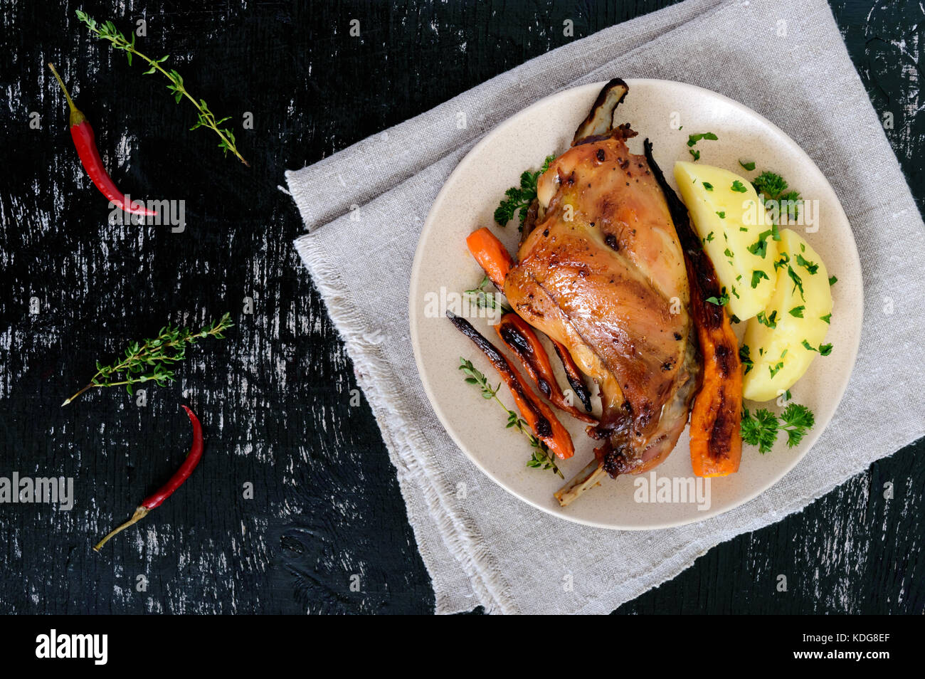 Fried rabbit leg, garnish of boiled potatoes, grilled carrots - on a ...