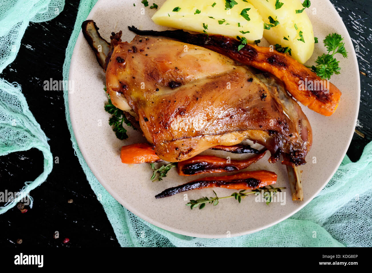 Fried rabbit leg, garnish of boiled potatoes, grilled carrots - on a ...
