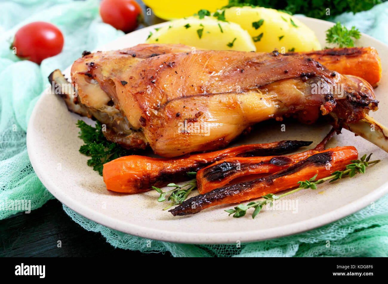Fried rabbit leg, garnish of boiled potatoes, grilled carrots - on a ...