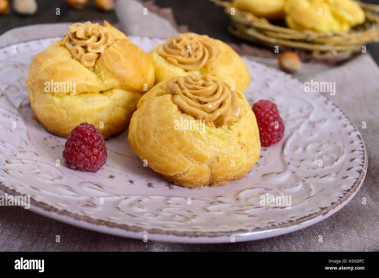 Delicious profiteroles with caramel nut cream on a ceramic plate on a ...