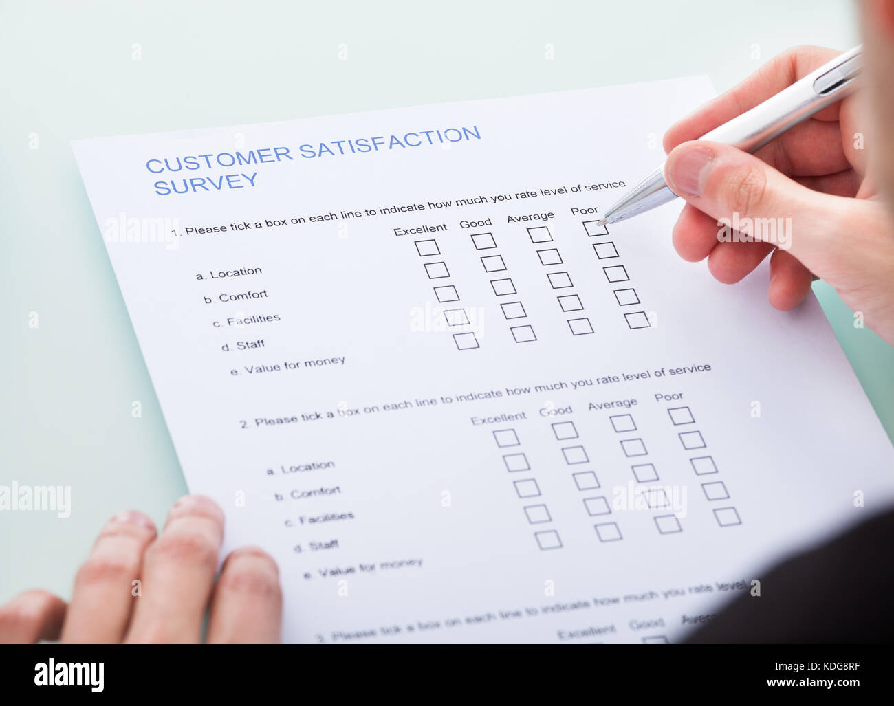 Close-up Of Man's Hand Filling Customer Survey Form Stock Photo - Alamy