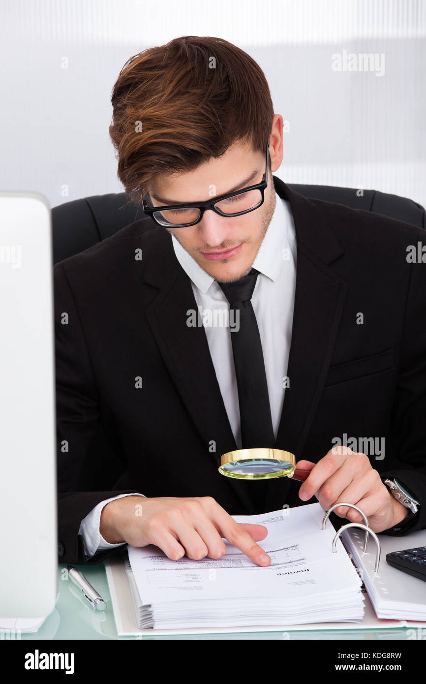 Businessman Looking At Document Through Magnifying Glass Stock Photo ...