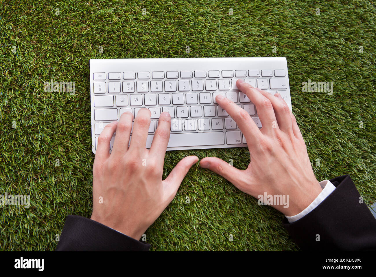 Close-up Of A Businessman Using Computer Keyboard Over Grass Stock ...