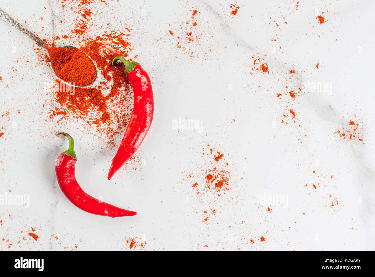 Raw fresh organic and dried ground chili pepper on white marble ...