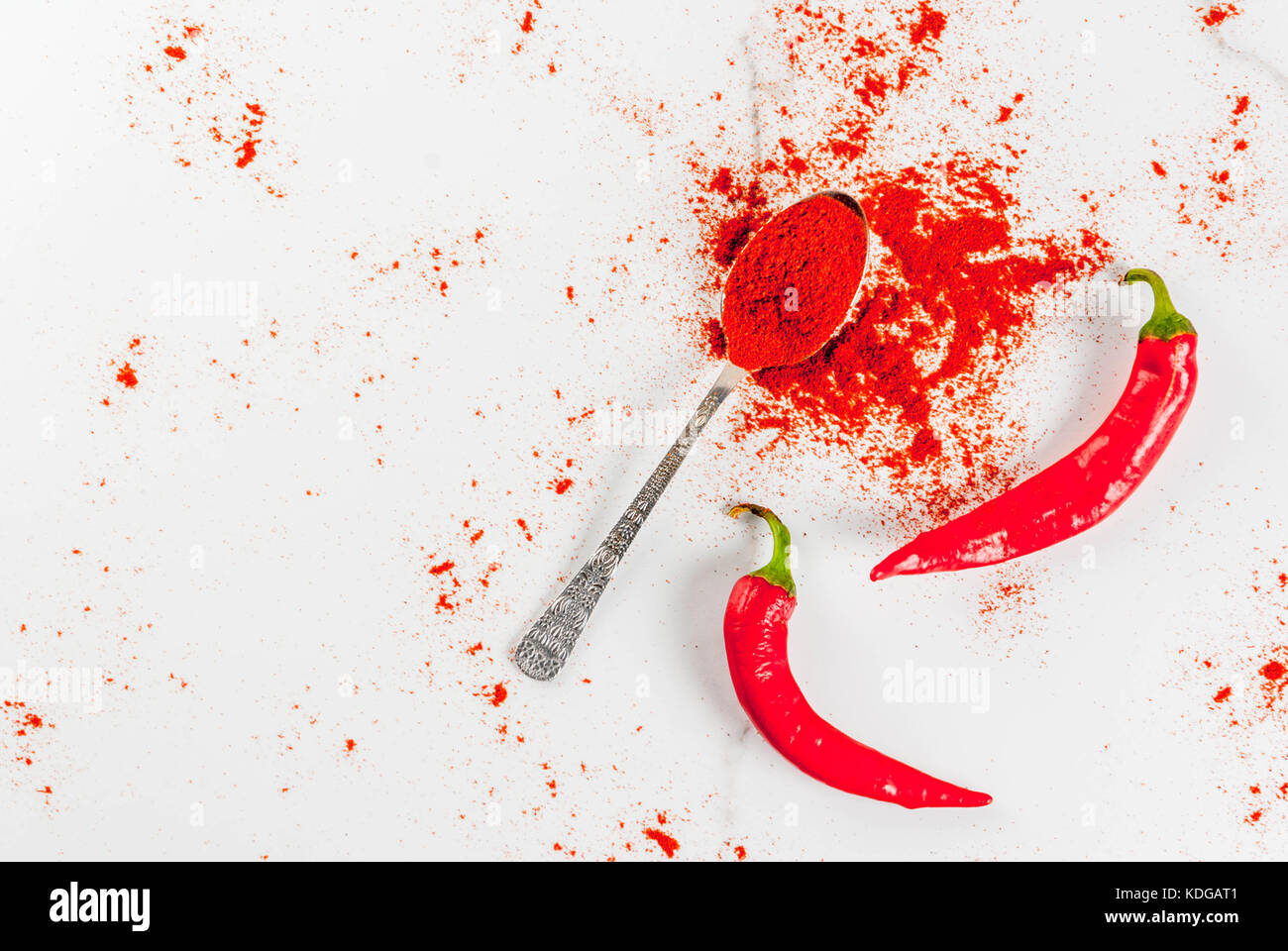 Raw fresh organic and dried ground chili pepper on white marble ...