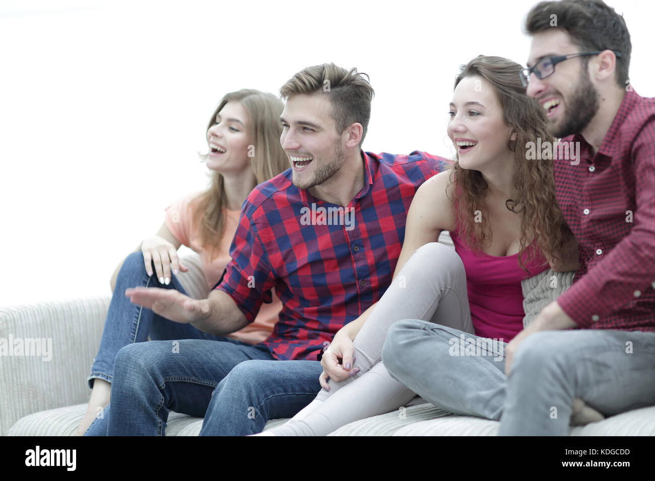 young friends sitting on the couch and rooting for their favorite team ...