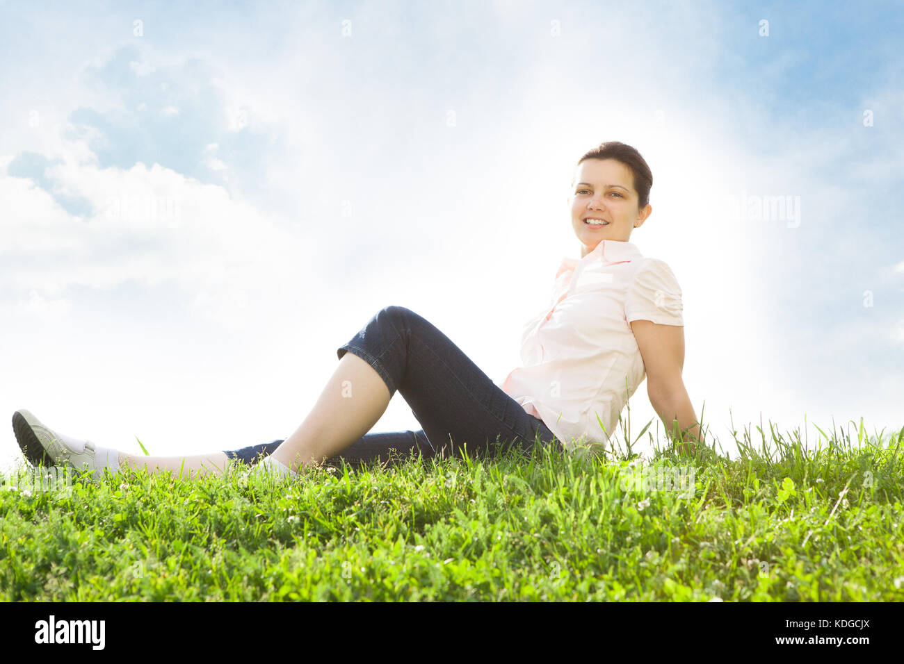 Portrait Of Young Woman Relaxing In Grassland Stock Photo - Alamy