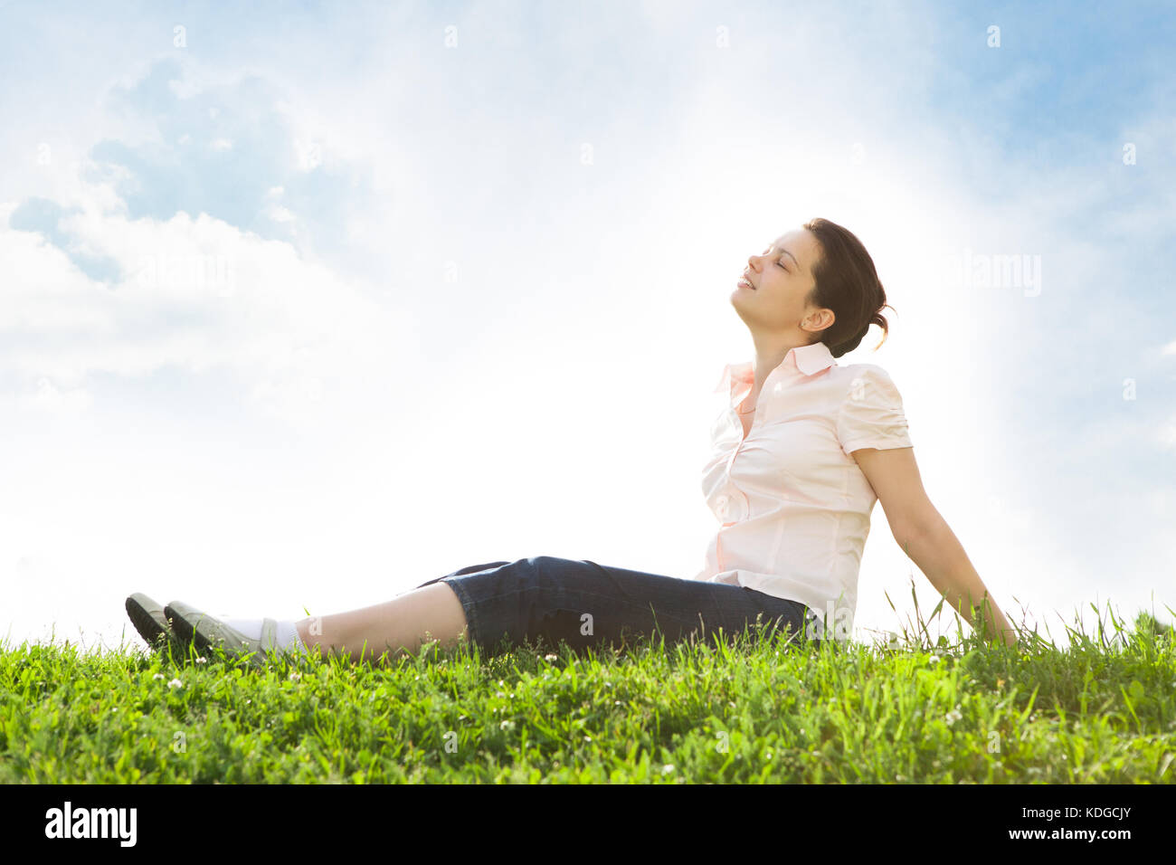Portrait Of Young Woman Relaxing In Grassland Stock Photo - Alamy