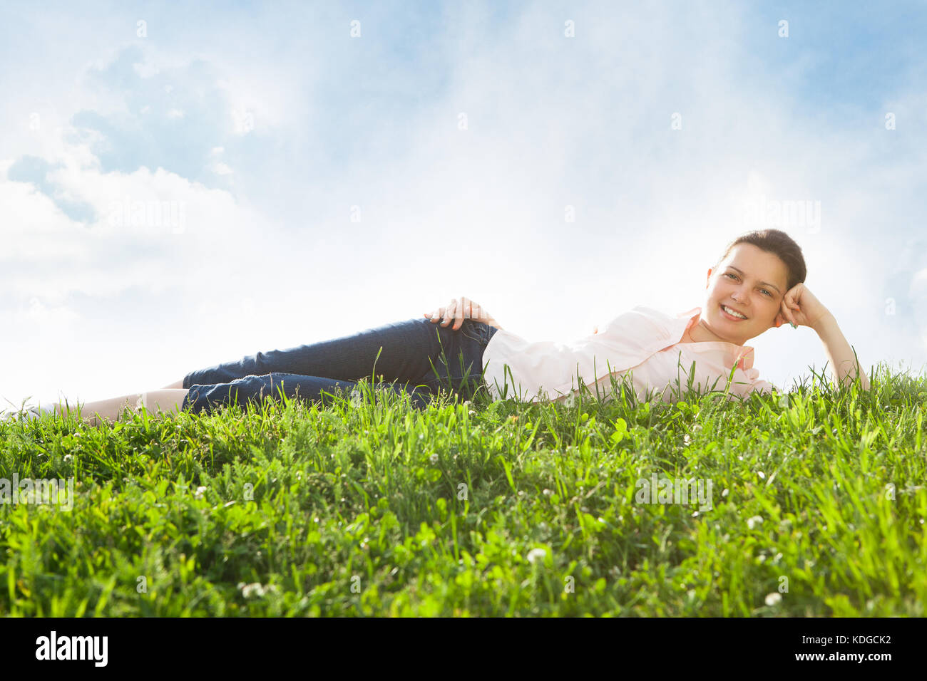 Portrait Of Young Woman Relaxing In Grassland Stock Photo - Alamy