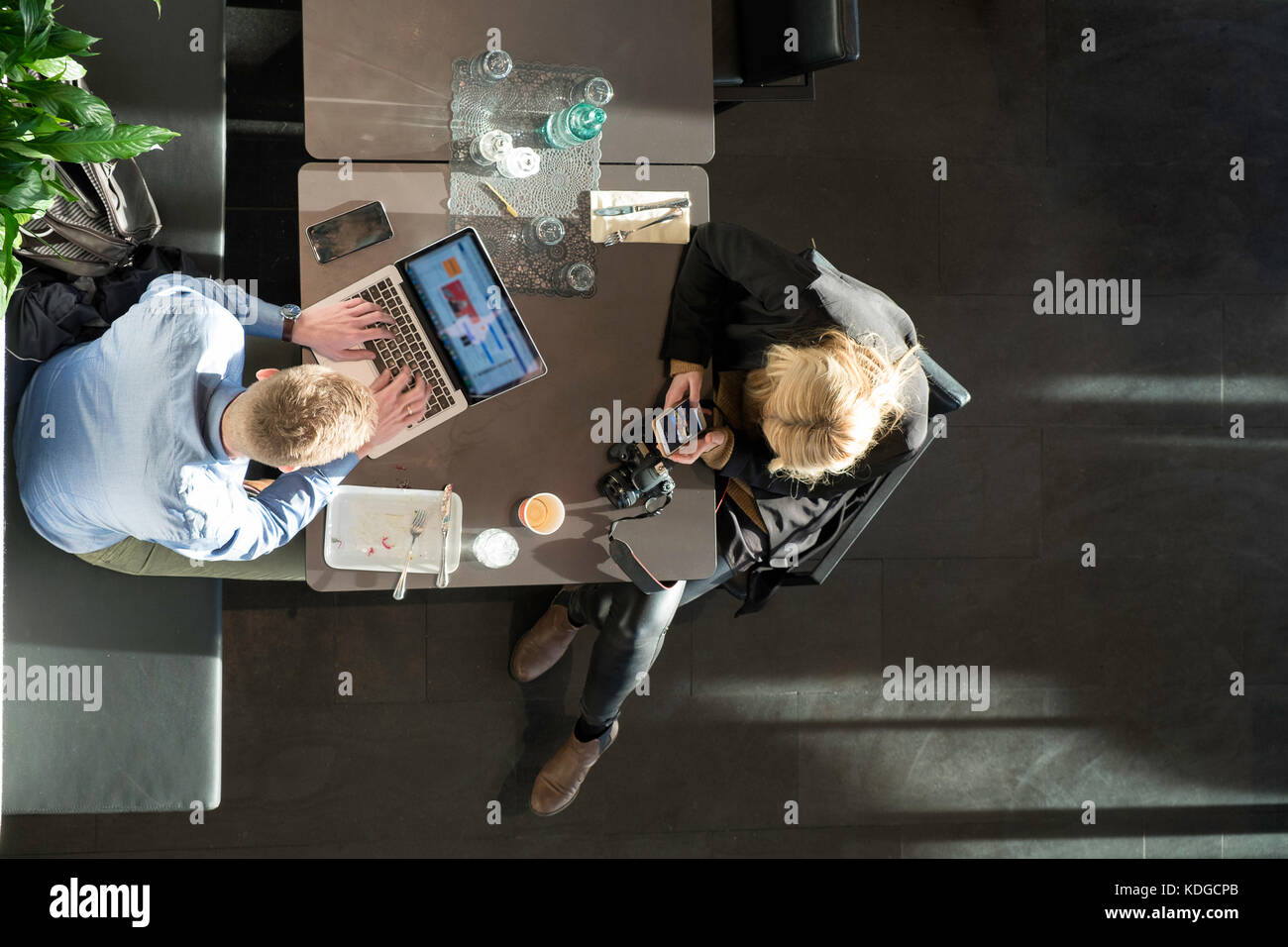 Real life image shot from above of a young couple using laptop and ...