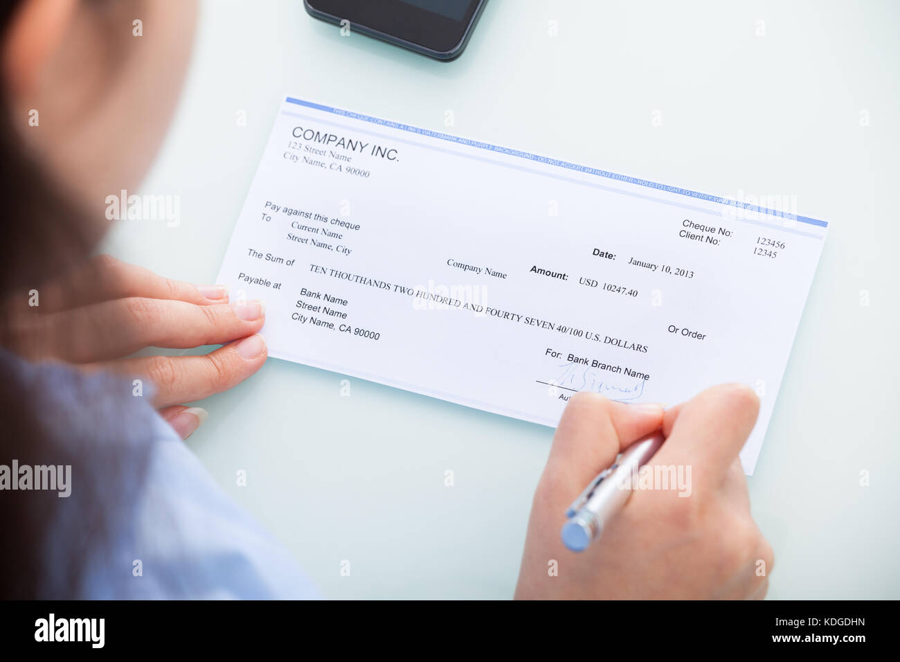 Close-up Of A Businesswoman Filling Blank Cheque At Desk Stock Photo ...