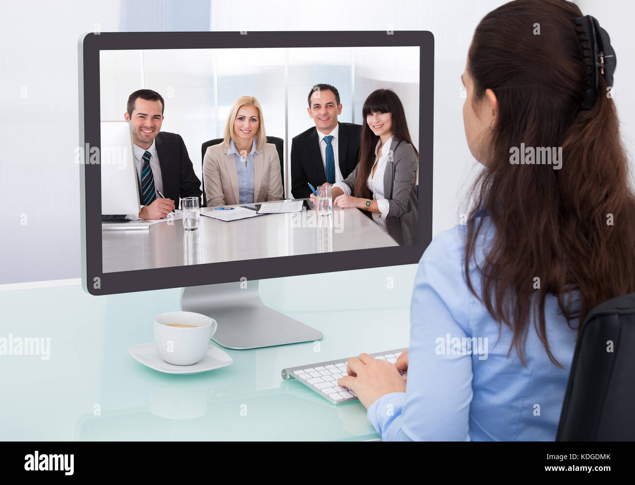 Businesswoman Sitting At A Desk Watching An Online Presentation On The ...