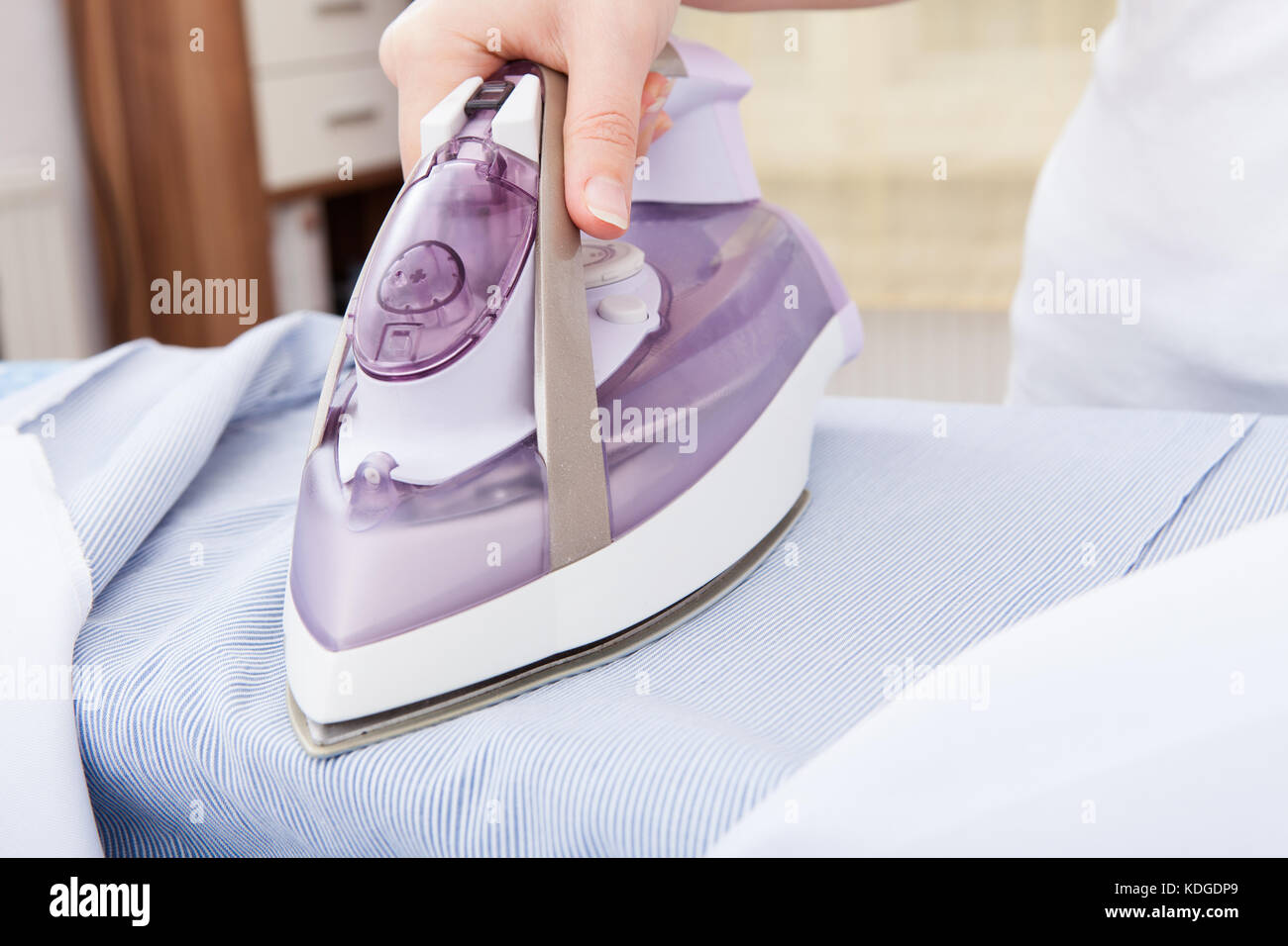 Close-up Of Woman's Hand Ironing Clothes On Ironing Board Stock Photo ...