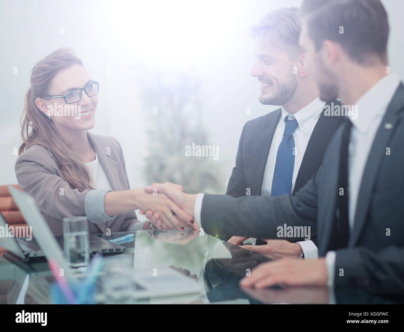 Happy business partners shaking hands in an office Stock Photo - Alamy