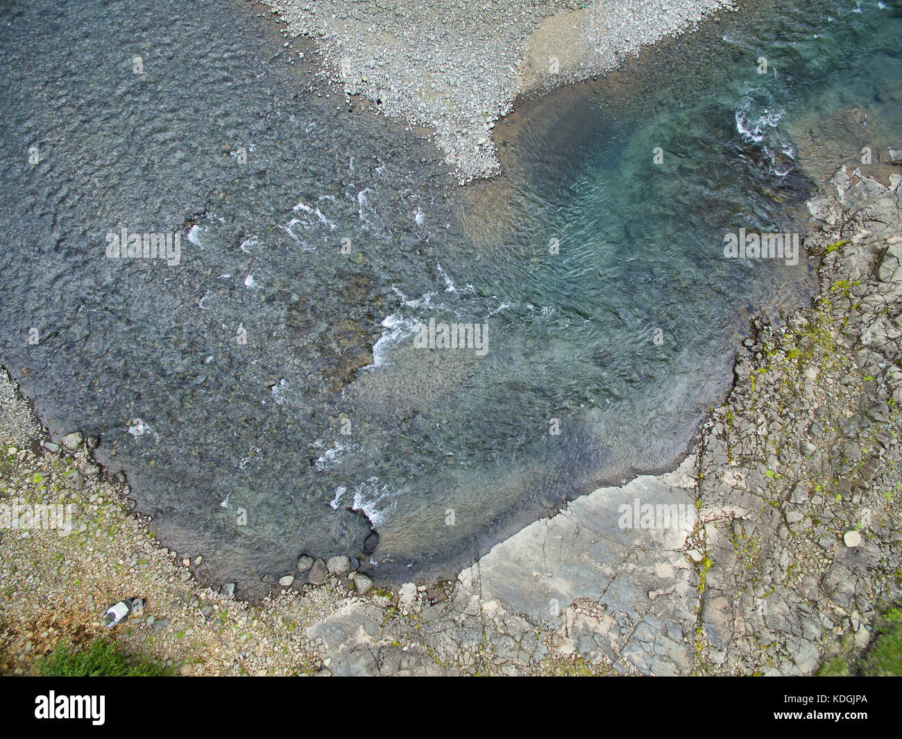 Aerial view of a bend in a fishing river, fisherman standing on the ...
