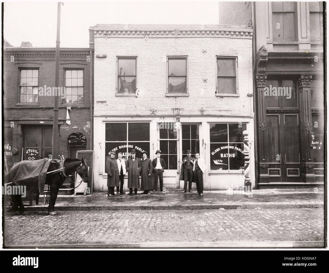 Men standing on the sidewalk in front of the Globe Shaving Parlor at ...