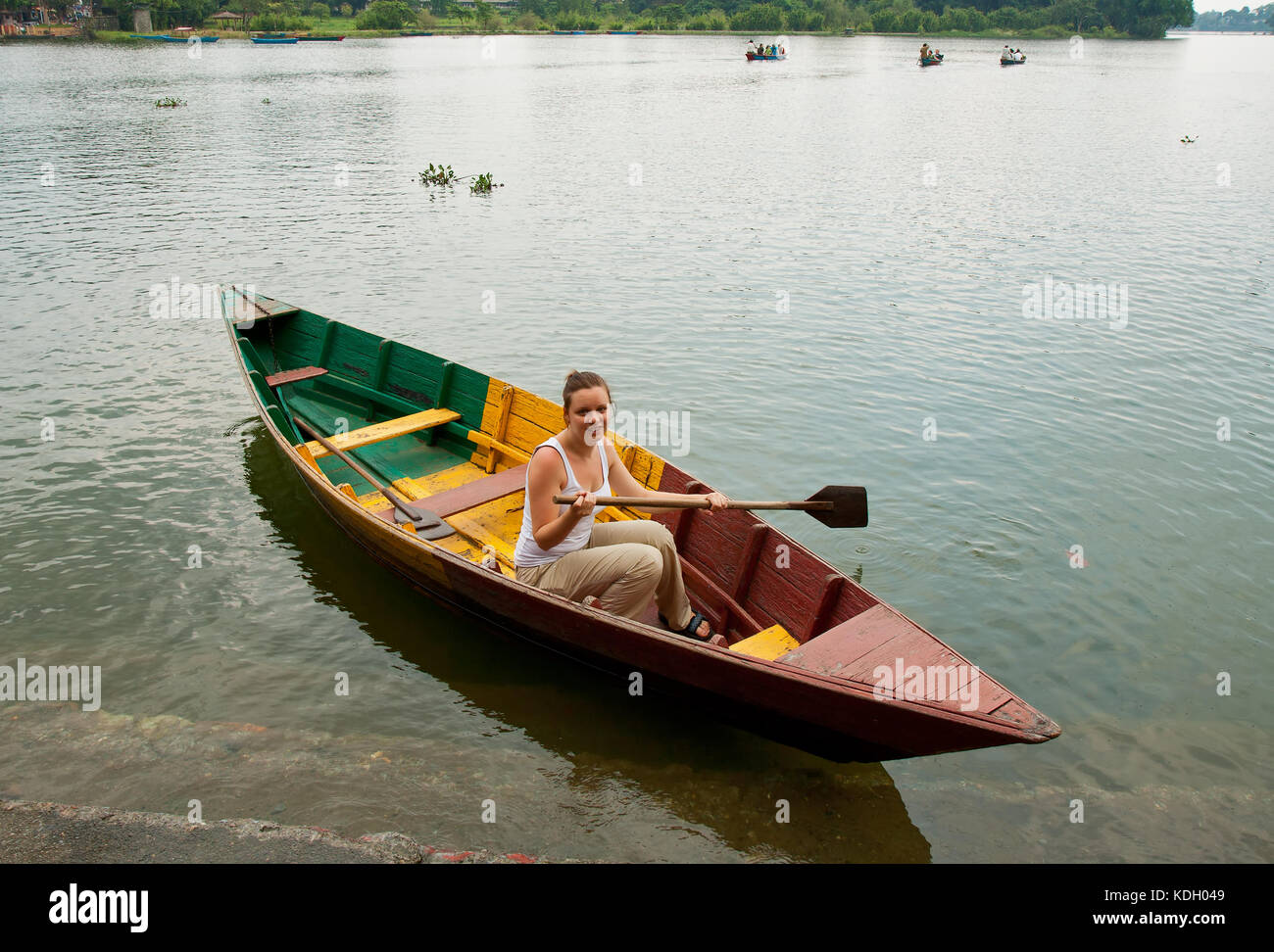 A nice girl in a boat rowing one oar Stock Photo - Alamy