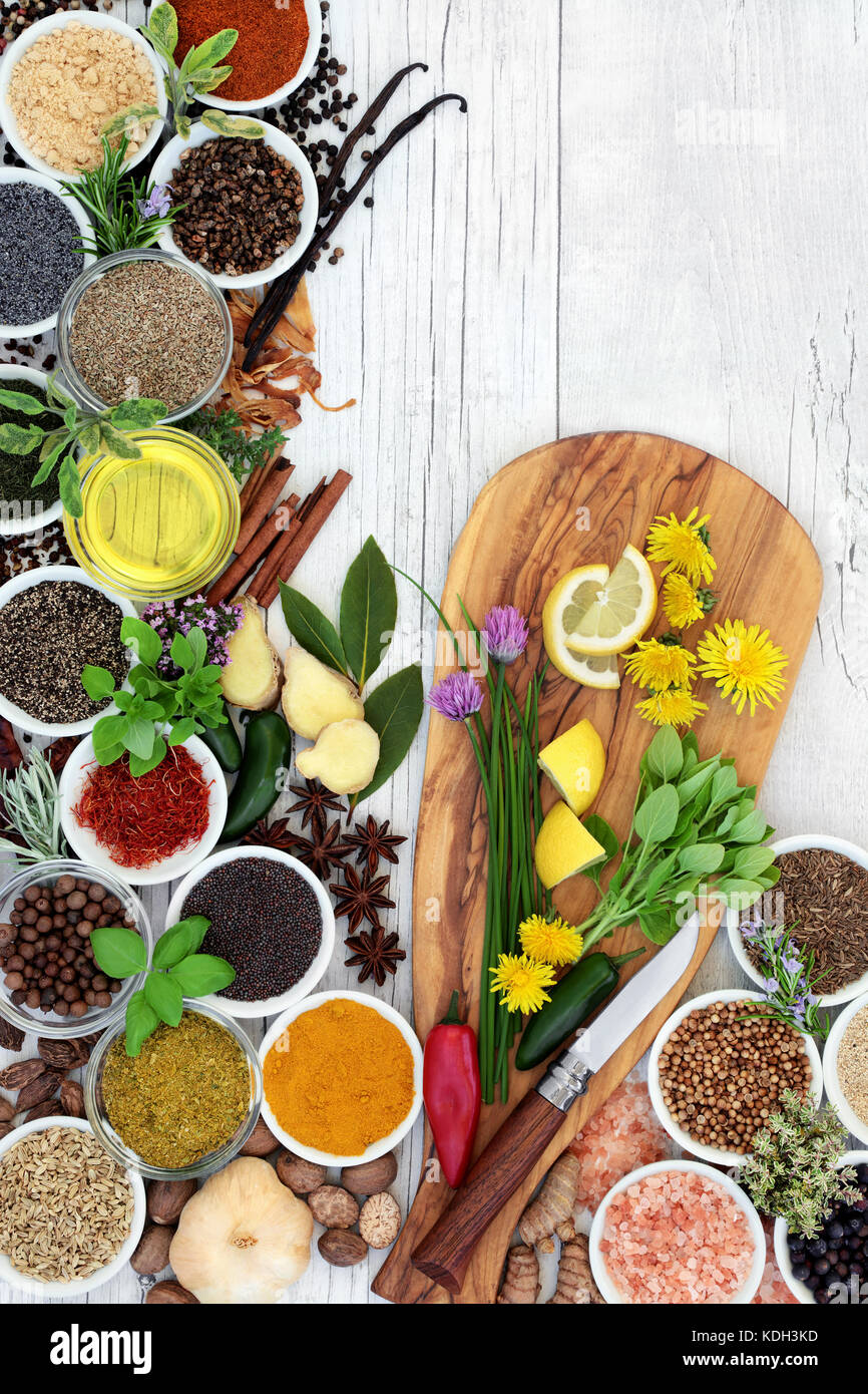 Herbs, spices and edible fresh flowers with olive oil in bowls and ...