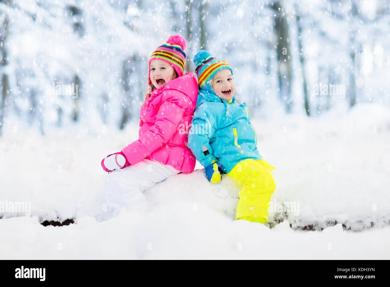 Kids playing in snow. Children play outdoors on snowy winter day. Boy ...