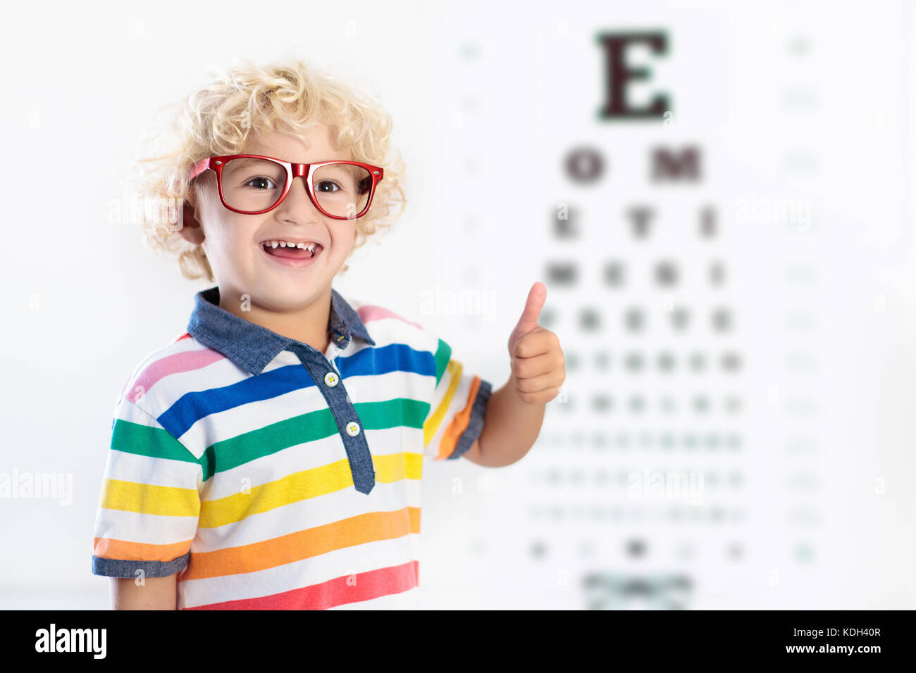 Child at eye sight test. Little kid selecting glasses at optician store ...