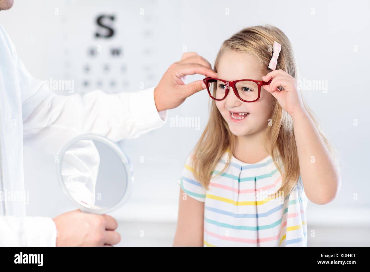 Child at eye sight test. Little kid selecting glasses at optician store ...
