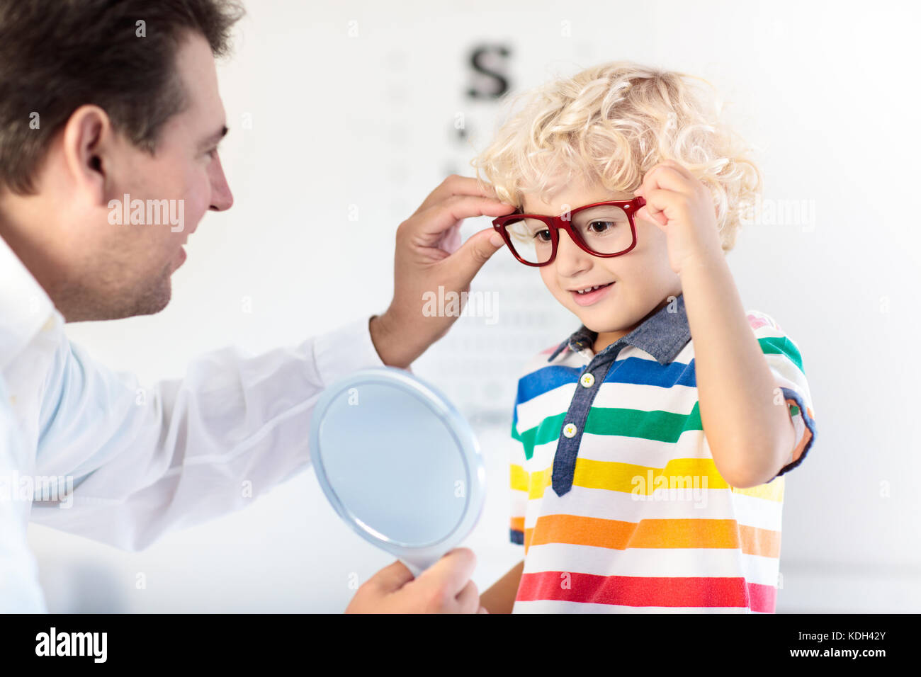 Child at eye sight test. Little kid selecting glasses at optician store ...