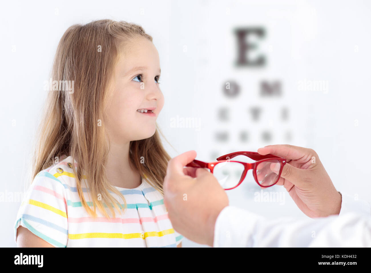 Child at eye sight test. Little kid selecting glasses at optician store ...