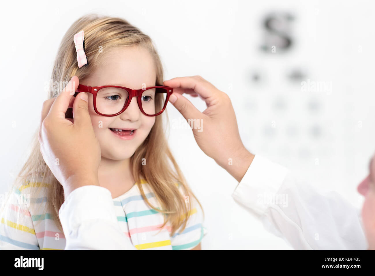 Child at eye sight test. Little kid selecting glasses at optician store ...
