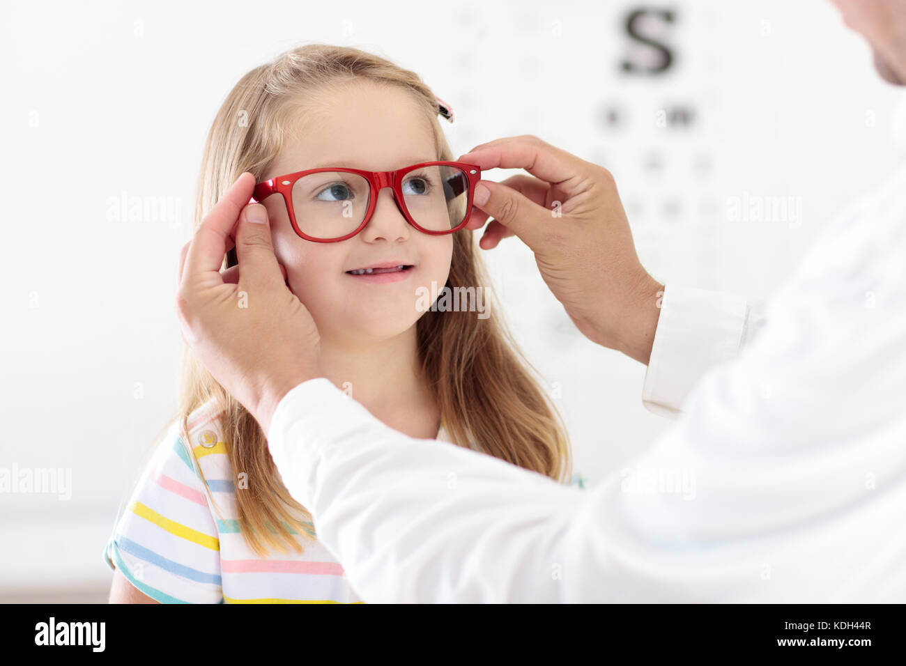 Child at eye sight test. Little kid selecting glasses at optician store ...