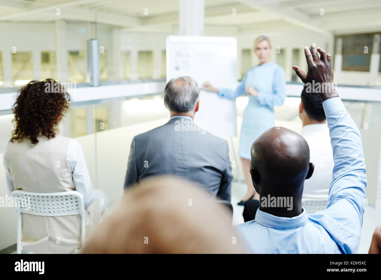 African-american businessman raising his arm to ask or answer question ...