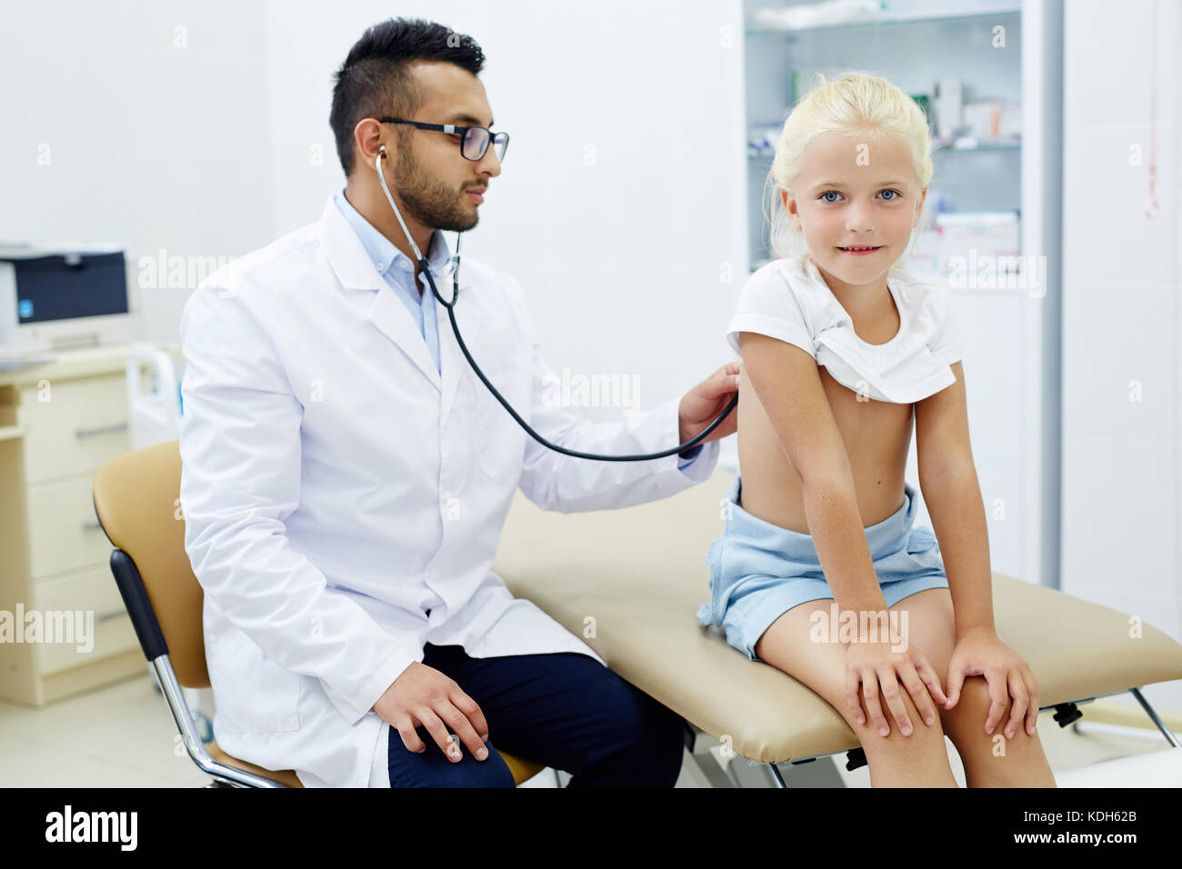 Adorable child havin examination of her lungs and breath in clinics ...
