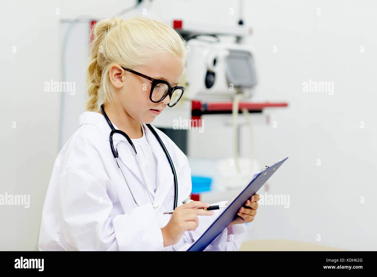 Little clinician making notes in medical document during work Stock ...