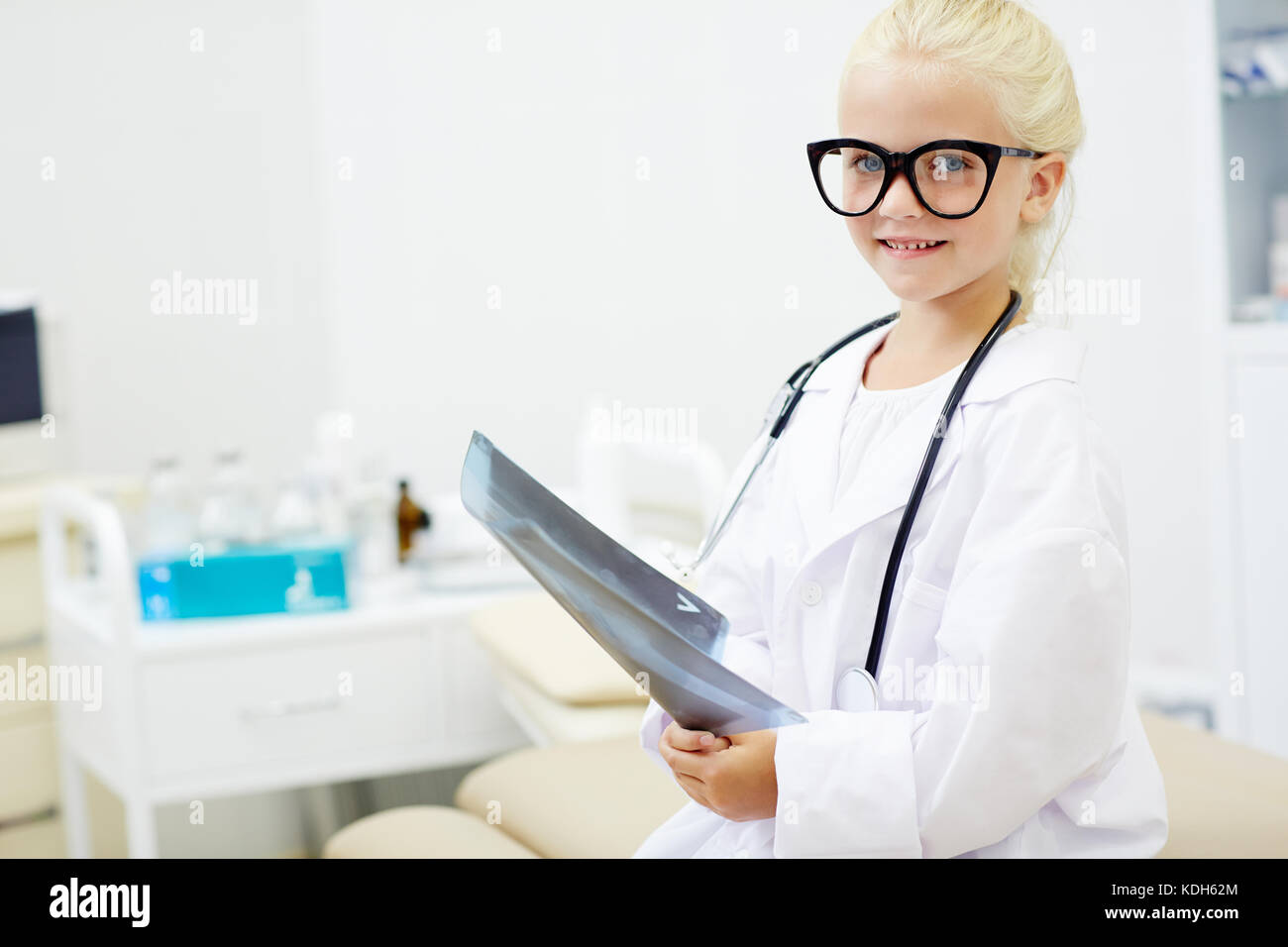 Little girl in medical uniform playing radiologist in kindergarten ...