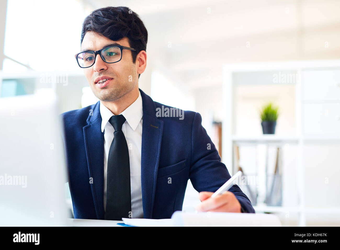 Confident salesman talking through video-chat to one of clients Stock ...
