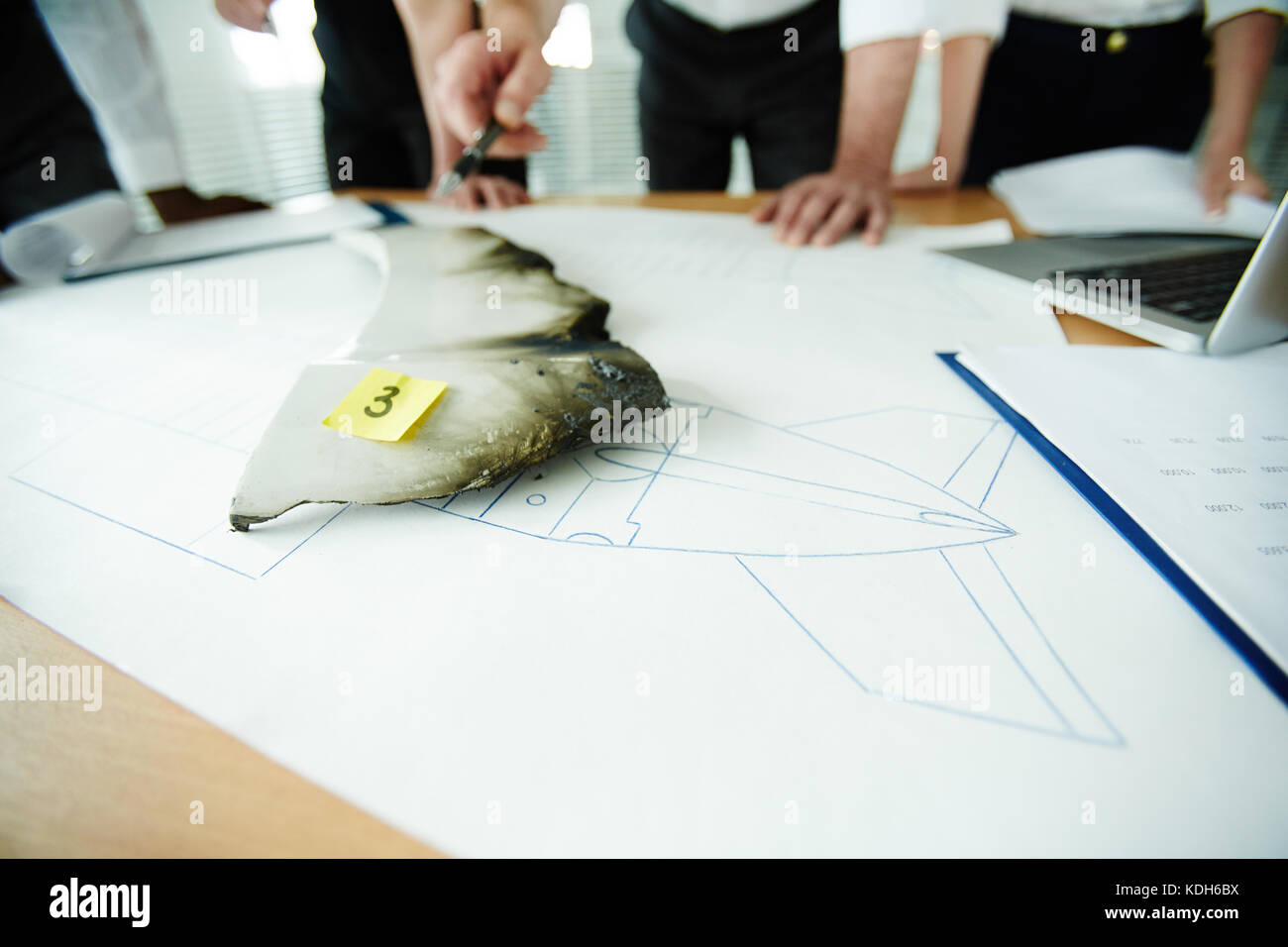 Piece of burned and crashed airplane wing on sketch of plane structure ...