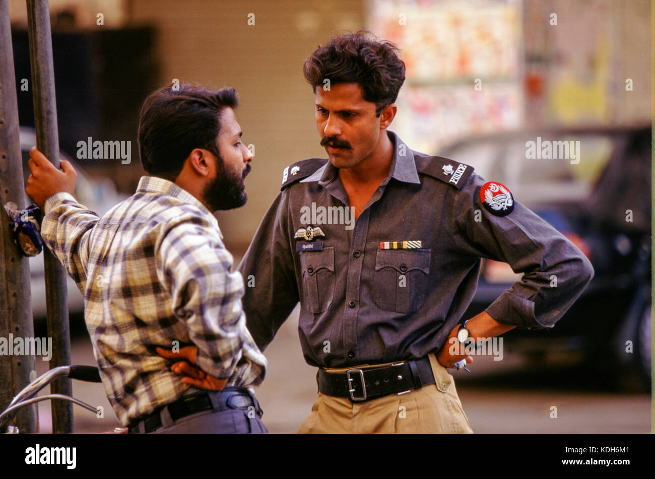 A police officer in conversation with another man on a street ...