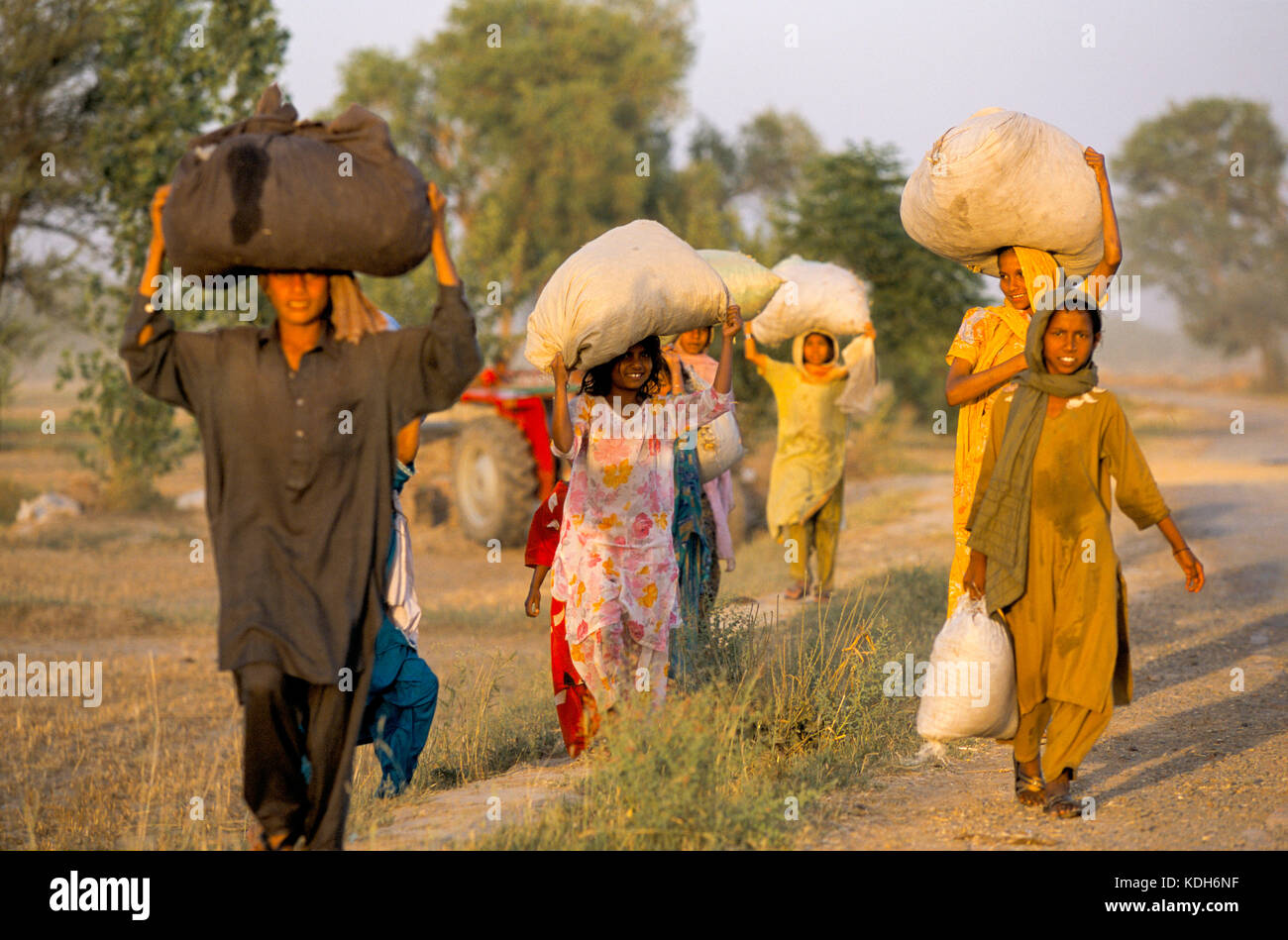 Women carry bags cloth on their heads on the way to market in the rural ...