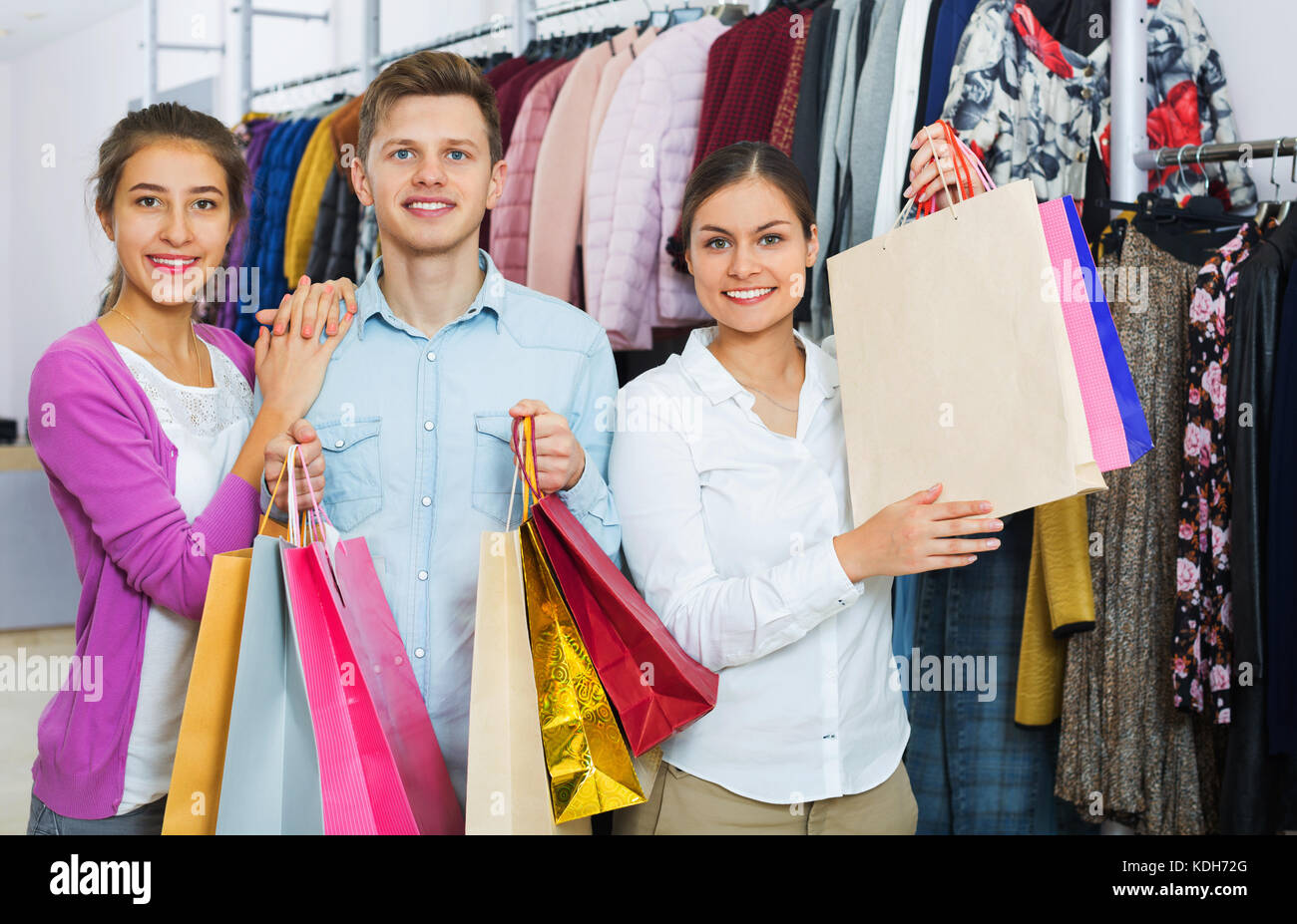 Happy young people with purchases in apparel shop Stock Photo - Alamy