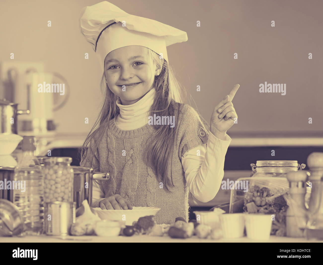Portrait of cute little girl in cook cap cooking veggies Stock Photo ...