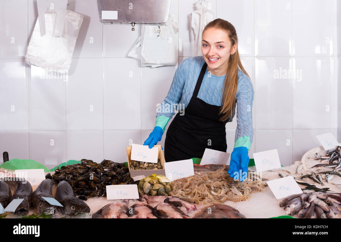 girl posing near display with cooled fish and seafood Stock Photo - Alamy