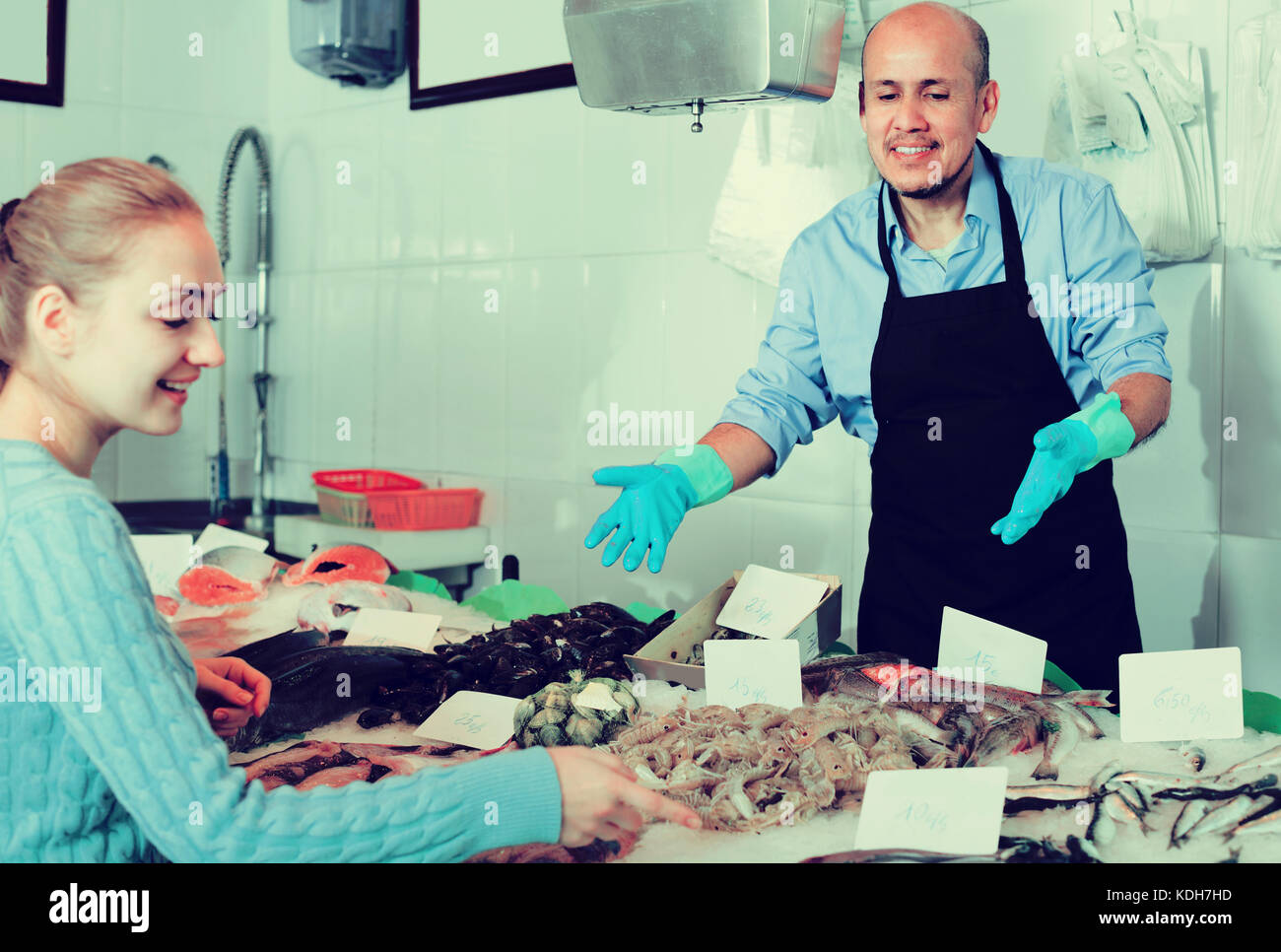 Young smiling blonde woman selecting cooled fish at fishery Stock Photo ...