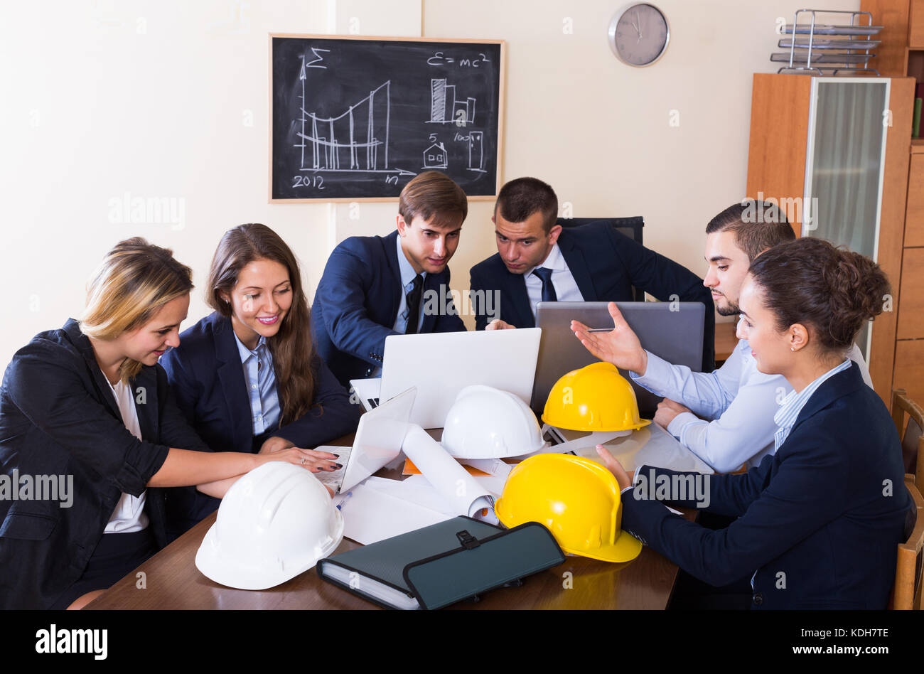 smiling team of architects working and brainstorming in office Stock ...