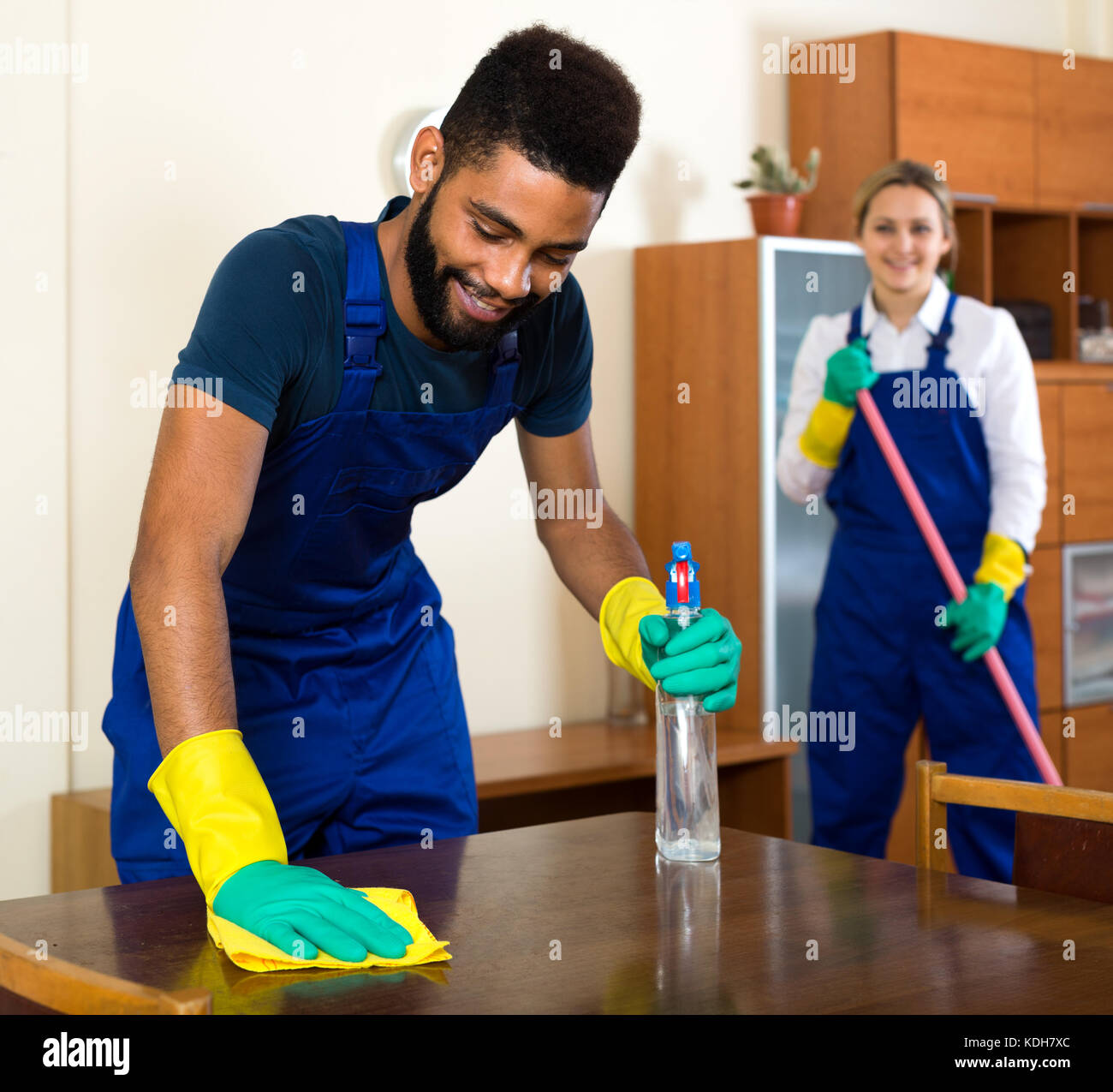 Portrait young professional cleaners cleaning and dusting in ordinary ...