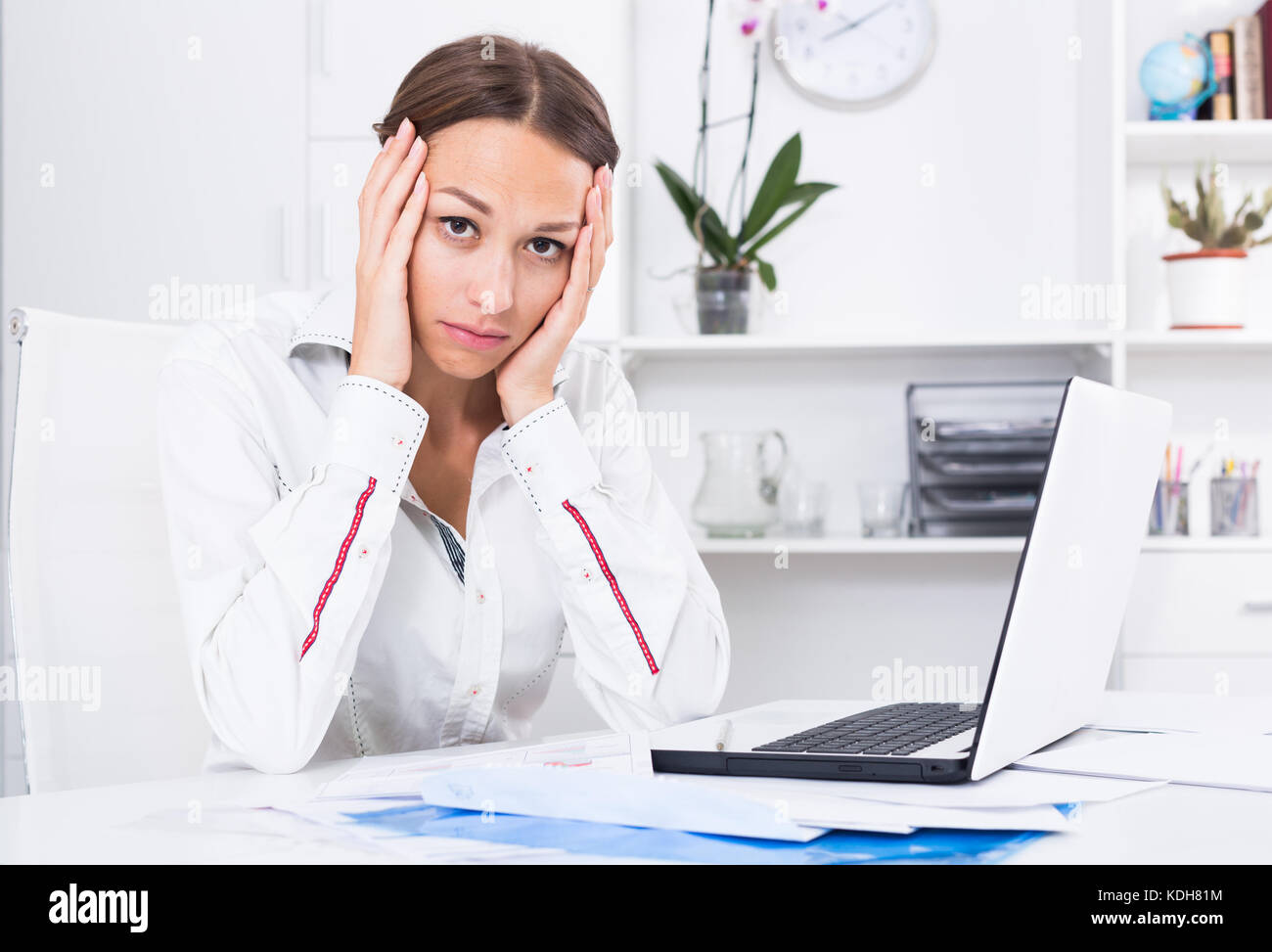 depressed young woman sitting with computer and having work troubles in ...